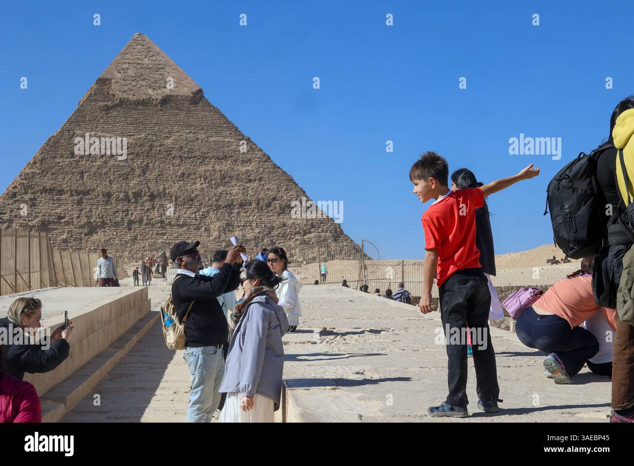 Tourists taking pictures at the pyramids in the Giza complex in Cairo ...