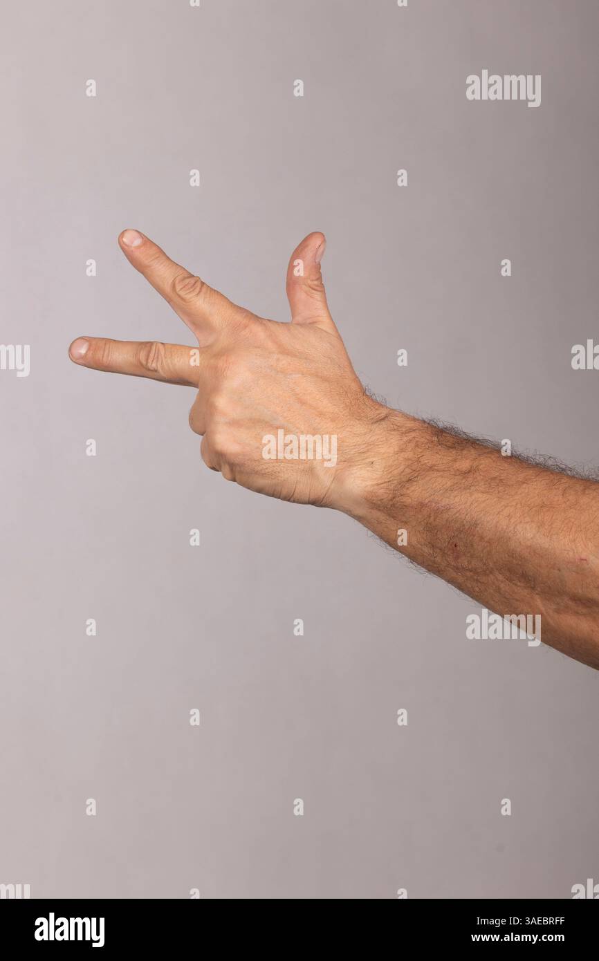 hairy male hand showing gesture with three fingers spread, number and ...