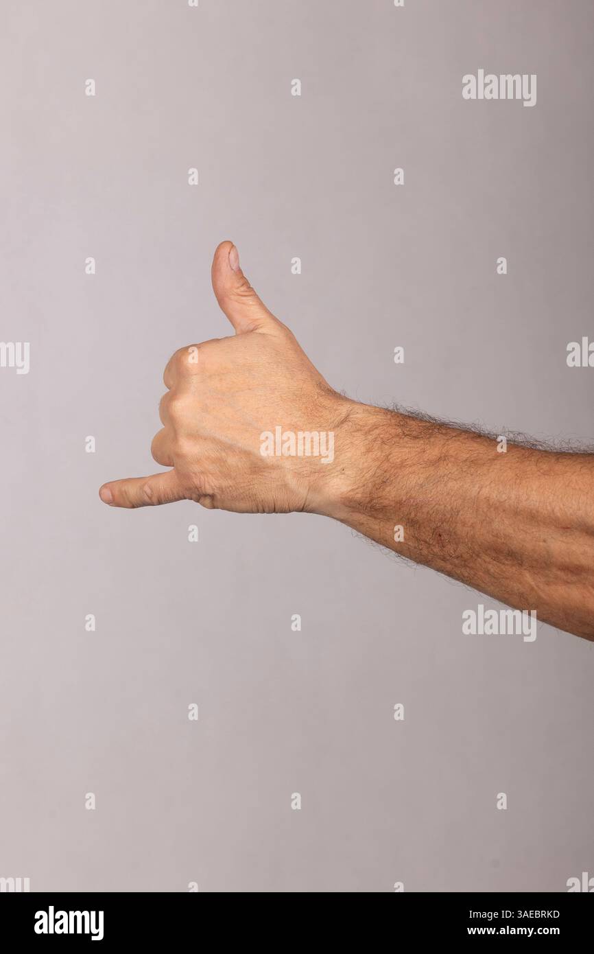 hairy male hand showing shaka gesture "I'm on a wave Stock Photo - Alamy