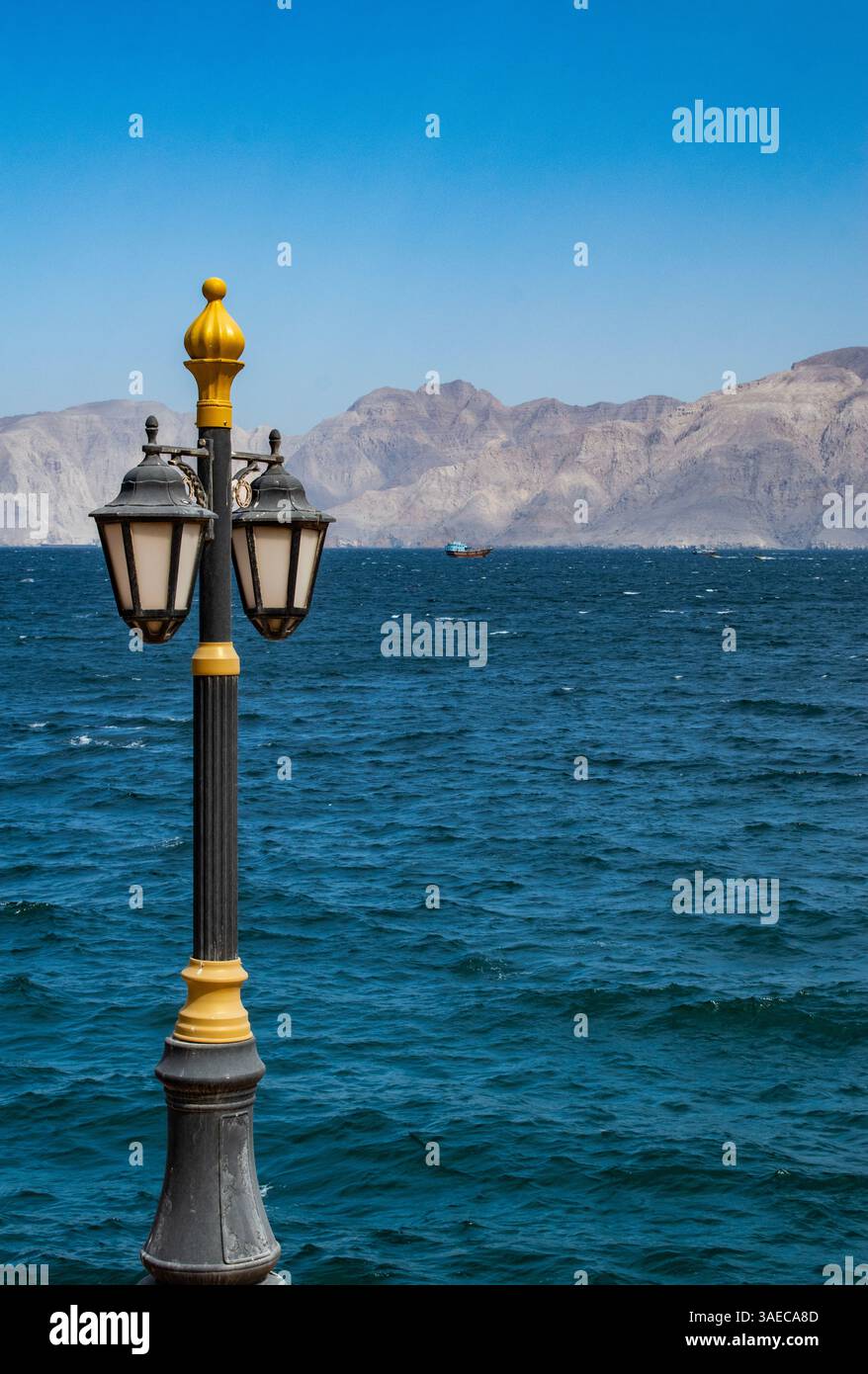 Oman: a street lamp facing the Strait of Hormuz on the seafront of one ...