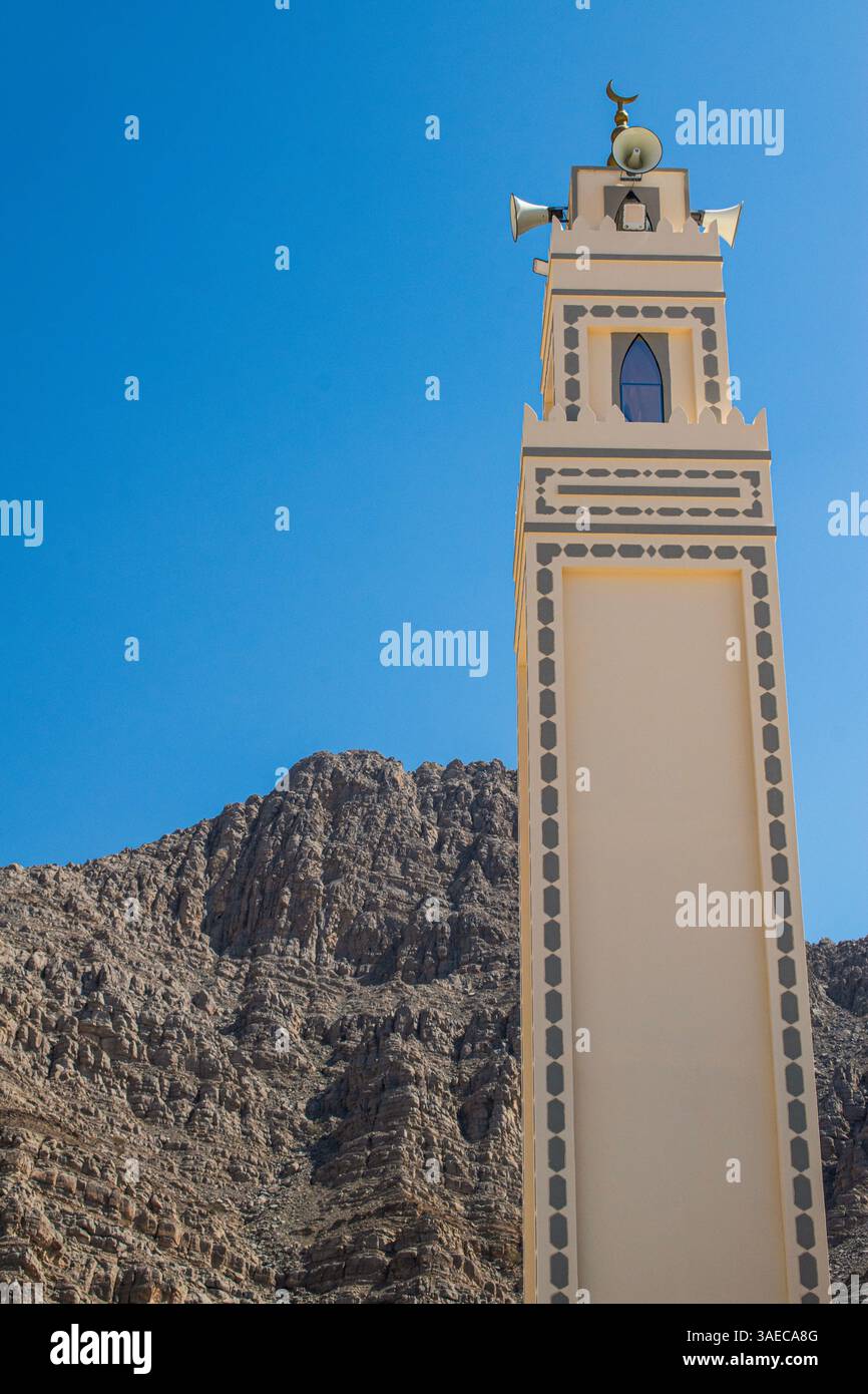 Oman: blue sky, a minaret and mountains, one of the many mosques of ...