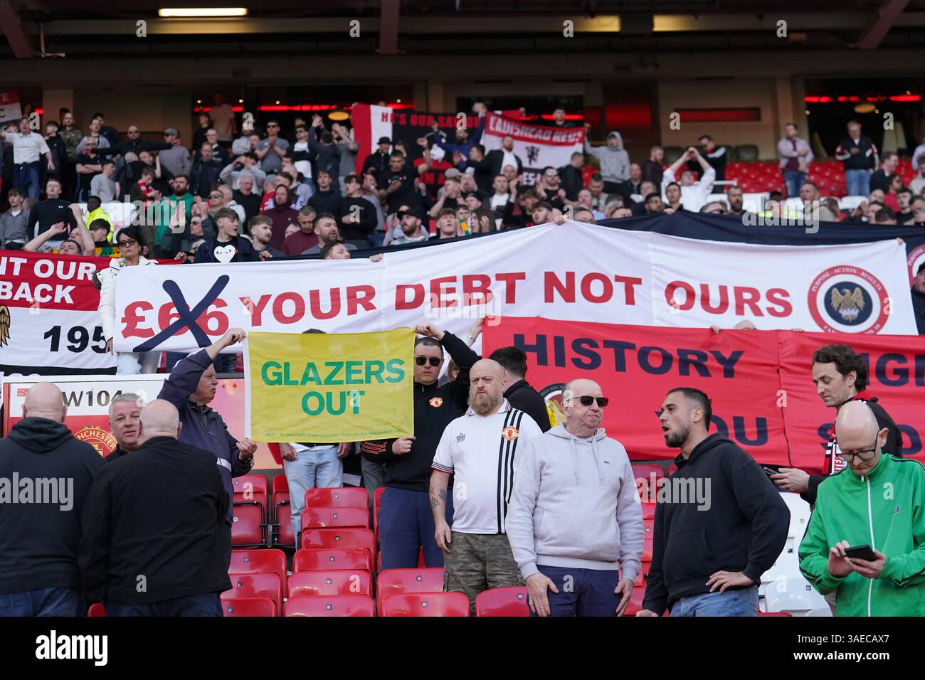Manchester United fans hold up banners during a sit-in protest against ...