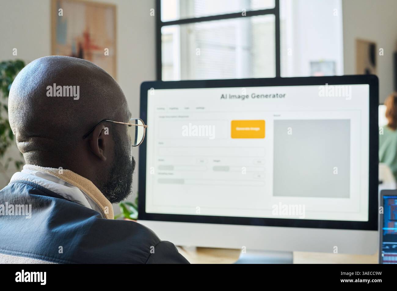 Focus on bald head of young African American designer sitting in front ...