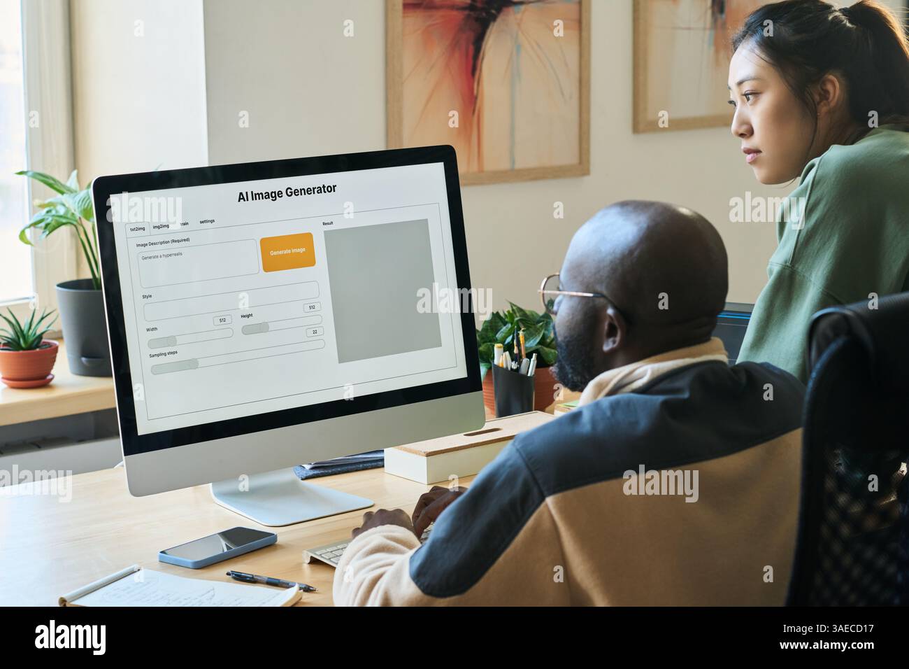 Two young intercultural office workers looking at screen of desktop ...