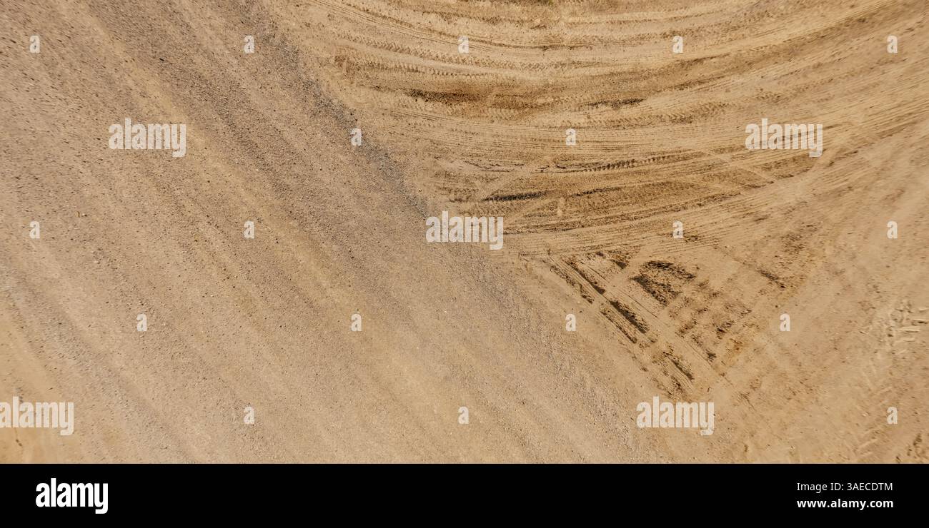 view from above on texture of dry road with tractor tire tracks in ...