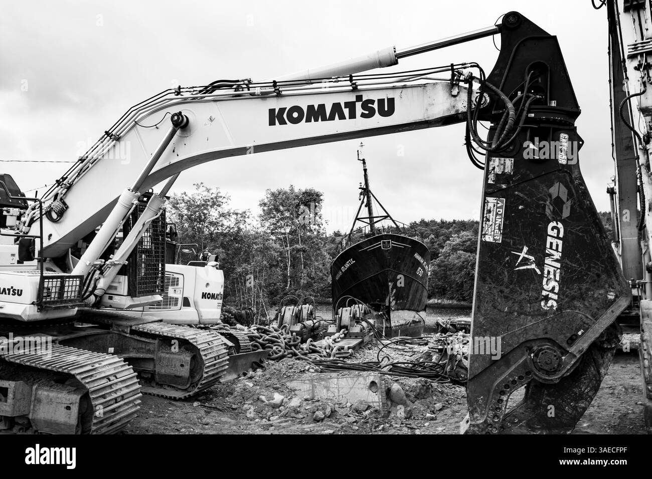 Boom of a Komatsu excavator frames a fishing trawler about to be ...