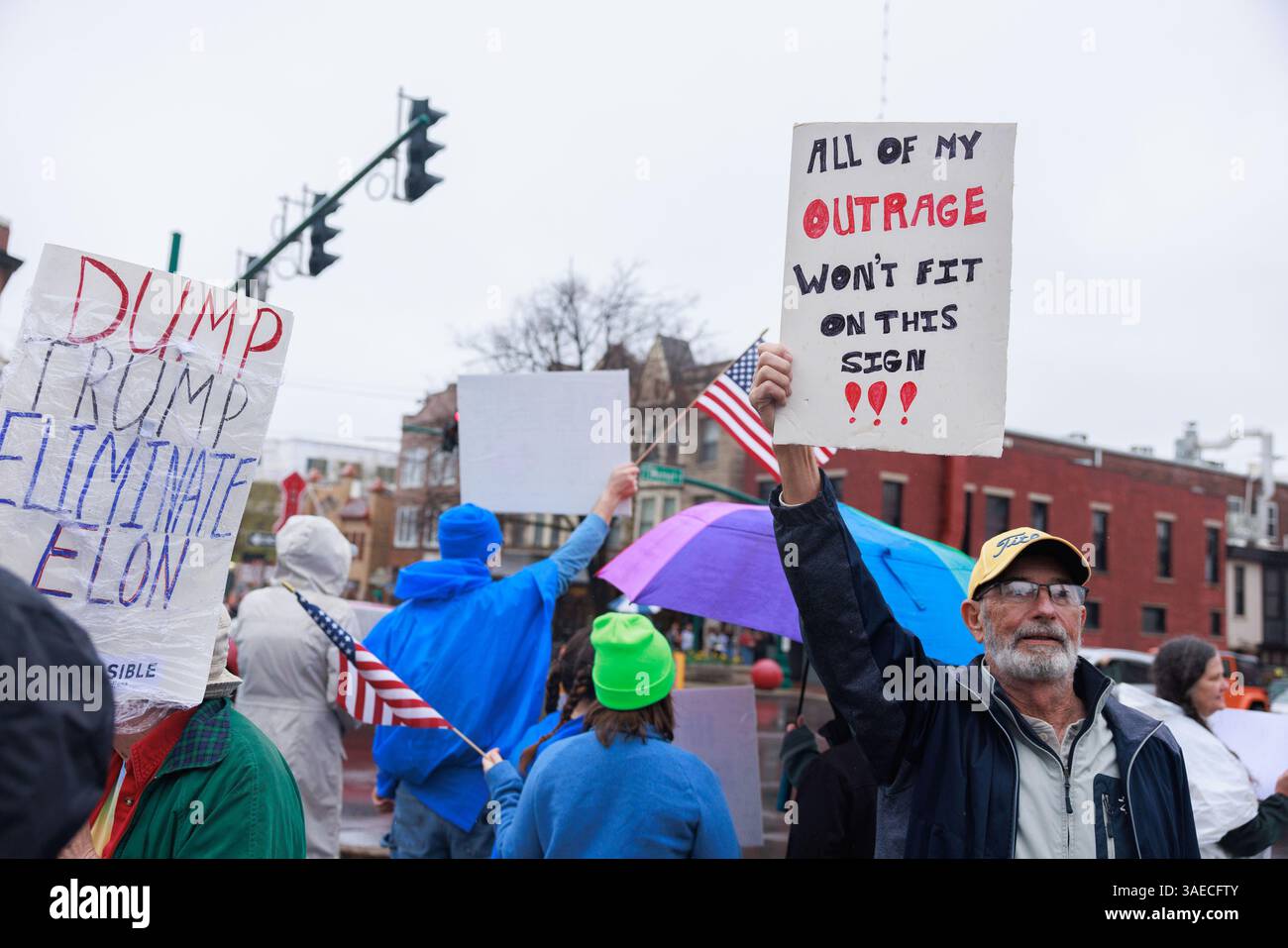 A man carries a placard reading, “All my outrage won't fit on this sign ...