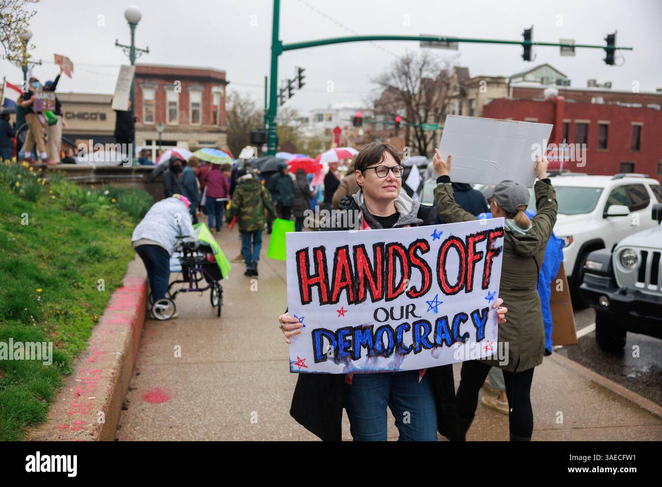 A woman carries a placard reading, “Hands off our Democracy,” during ...