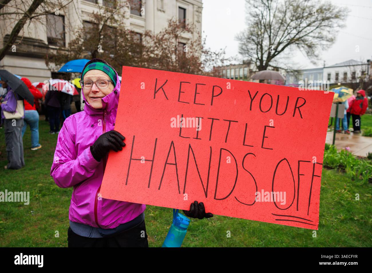 A woman carries a placard reading, “Keep your little hands off,” during ...