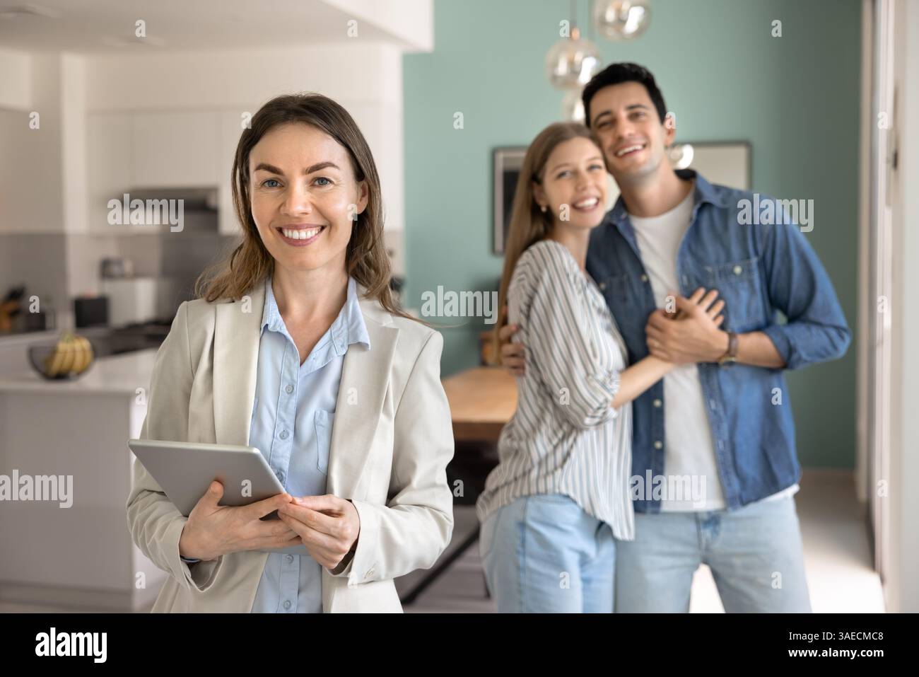 Real estate agent standing indoor with happy satisfied young couple ...
