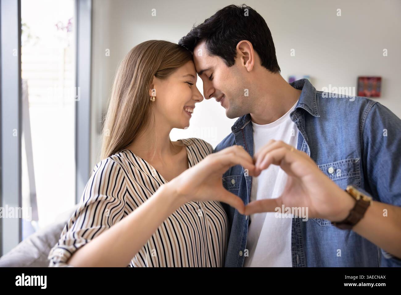 Beautiful couple in love joining fingers in heart symbol Stock Photo ...