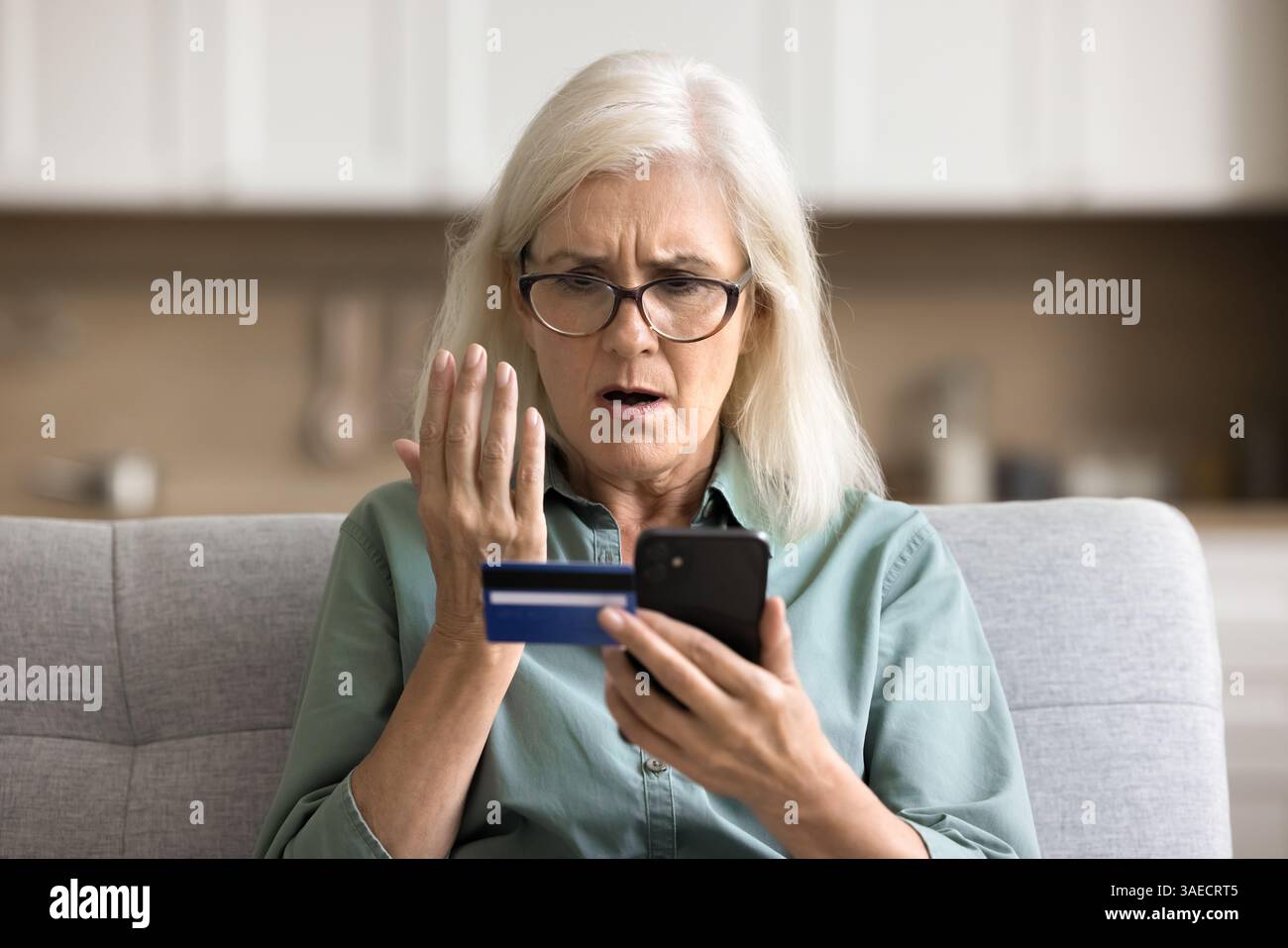 Nervous senior lady hold credit card look at phone screen Stock Photo ...