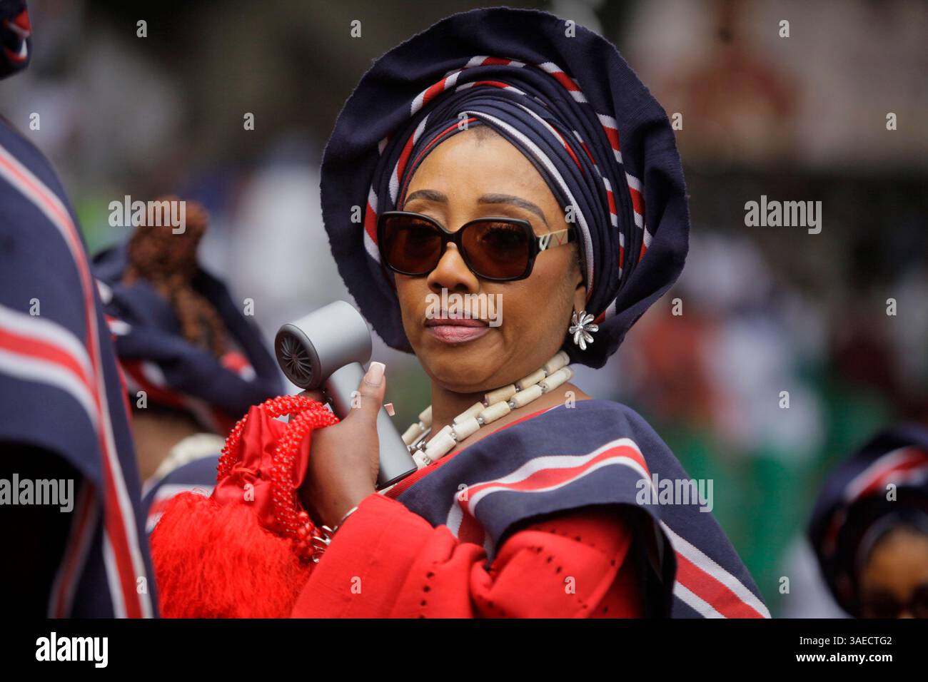 Abeokuta, Nigeria. 05th Apr, 2025. A woman holds a hand fan after ...