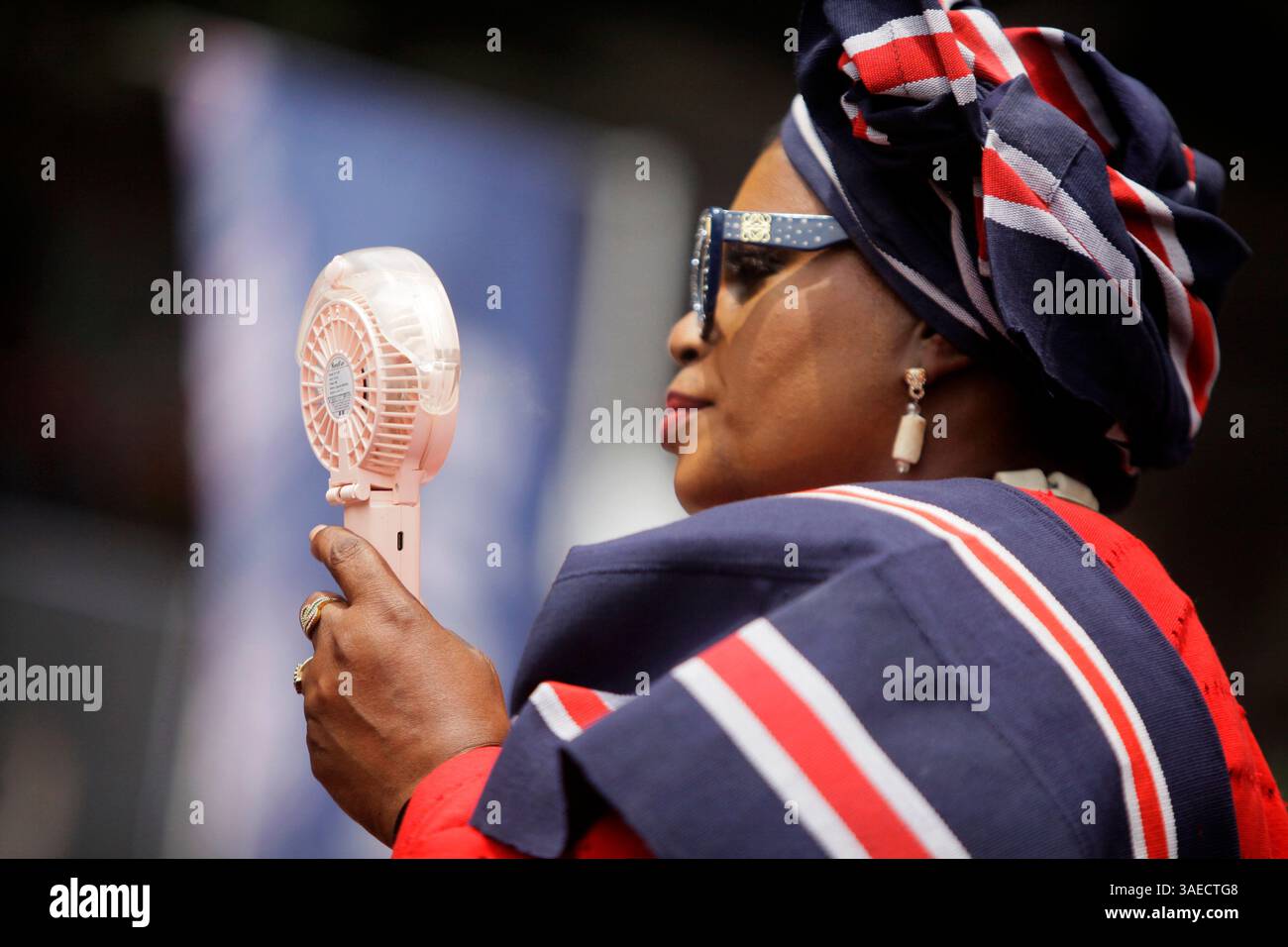 Abeokuta, Nigeria. 05th Apr, 2025. A woman holds a hand fan after ...