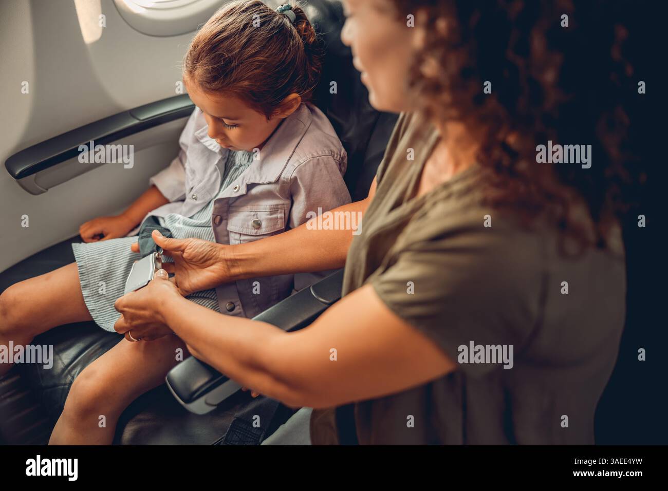 A Parent Helps Their Child to Securely Fasten the Seatbelt While on an ...