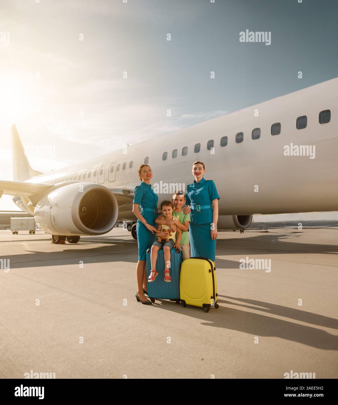 A Happy Family with Flight Attendants Nearby an Airplane at the Airport ...