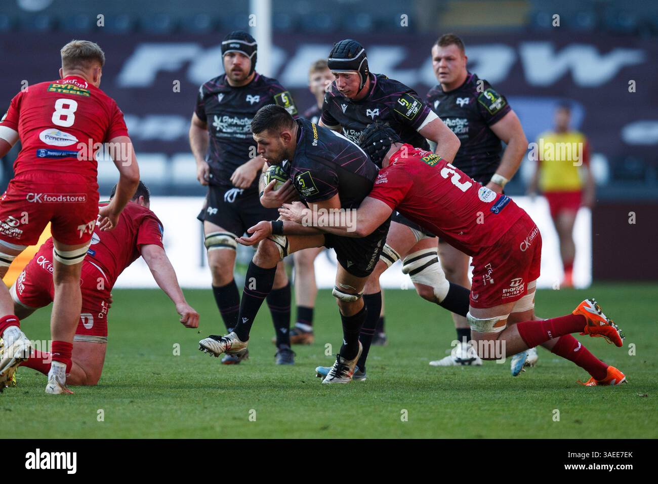 Swansea, UK. 6 April, 2025. Rhys Davies of Ospreys is tackled by Jac ...