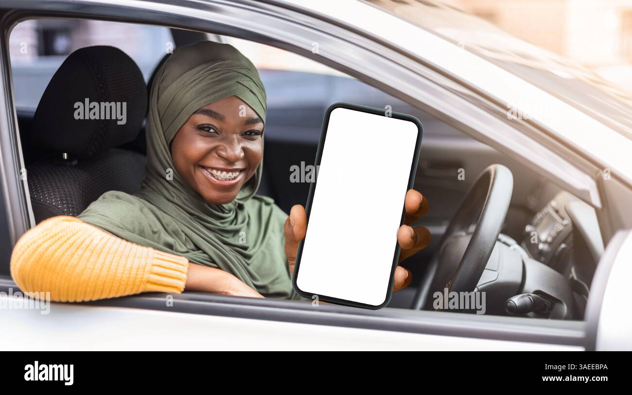 Happy black muslim woman in hijab sitting in car, showing driver ...