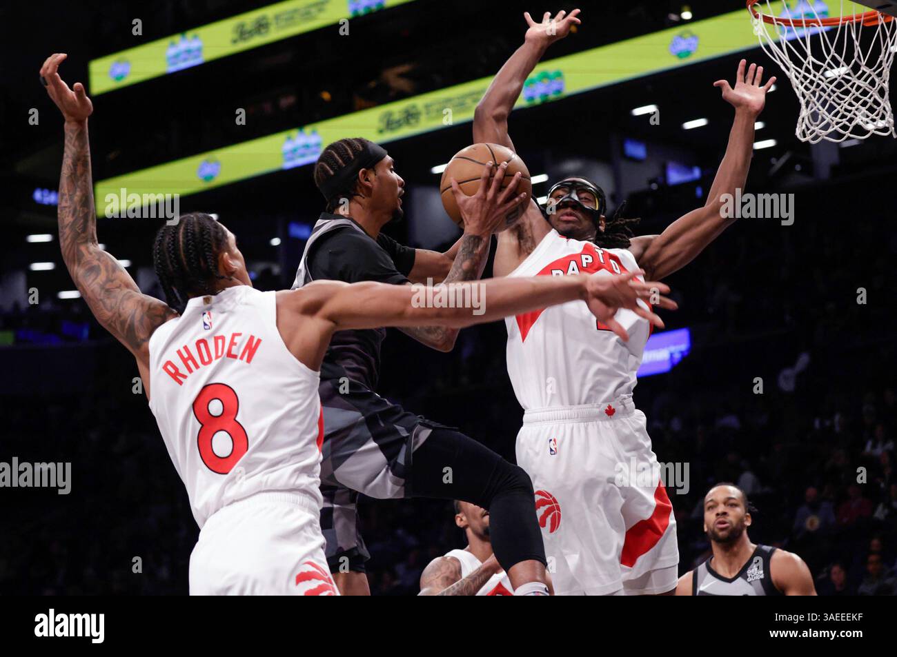 Toronto Raptors' Jared Rhoden (8) and Jonathan Mogbo, top right, defend ...