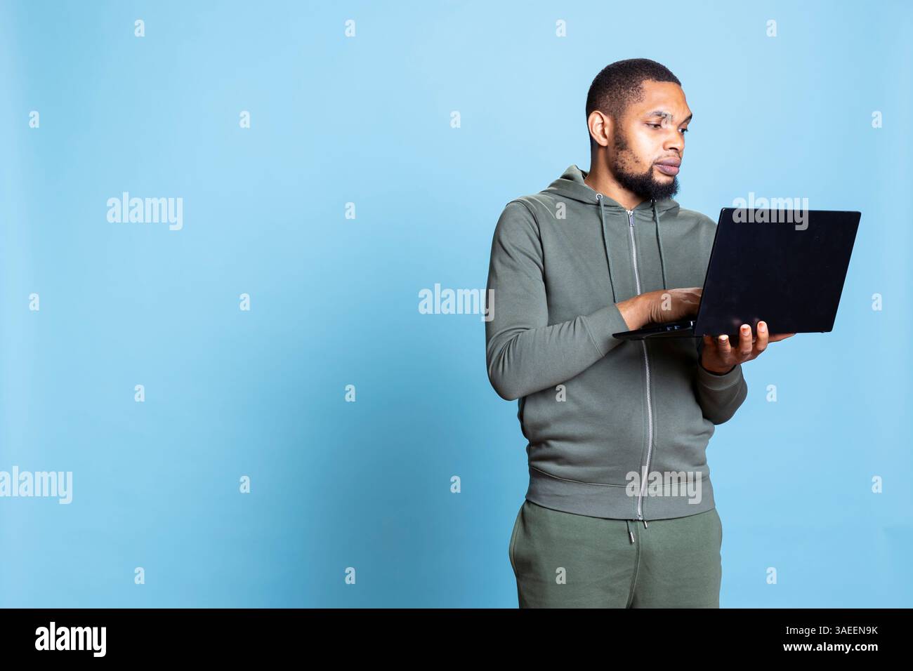 African american man typing on laptop keyboard and checking emails ...