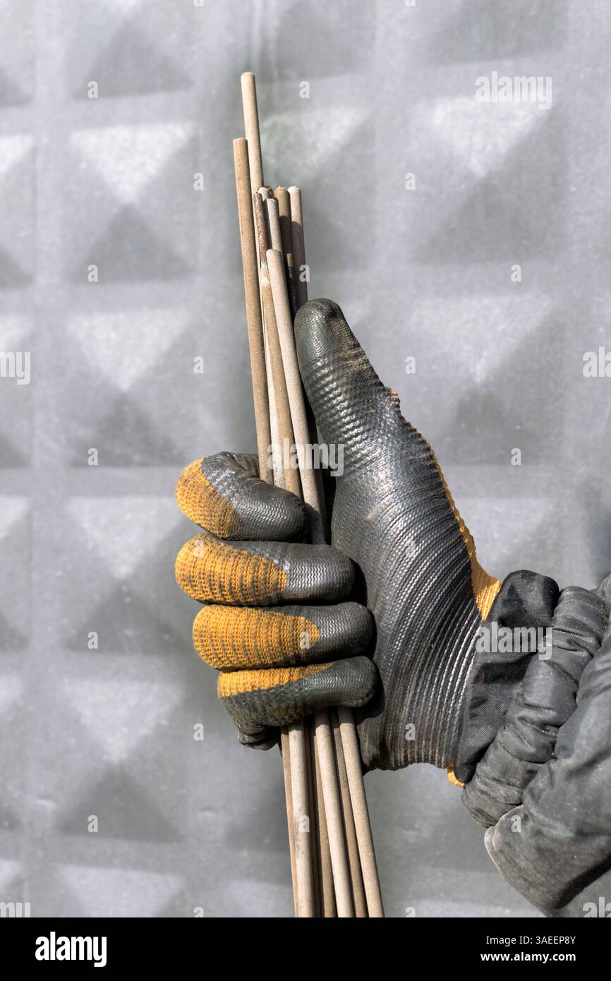 Welding electrodes in the hands of the worker. Steel welding rod ...
