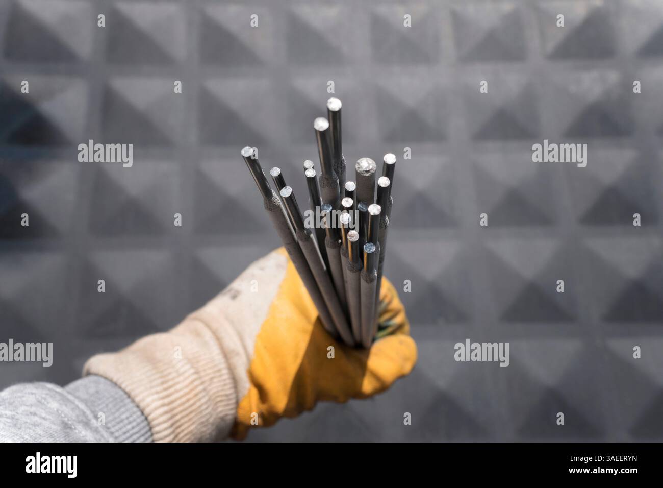 Welding electrodes in the hands of the worker. Steel welding rod ...
