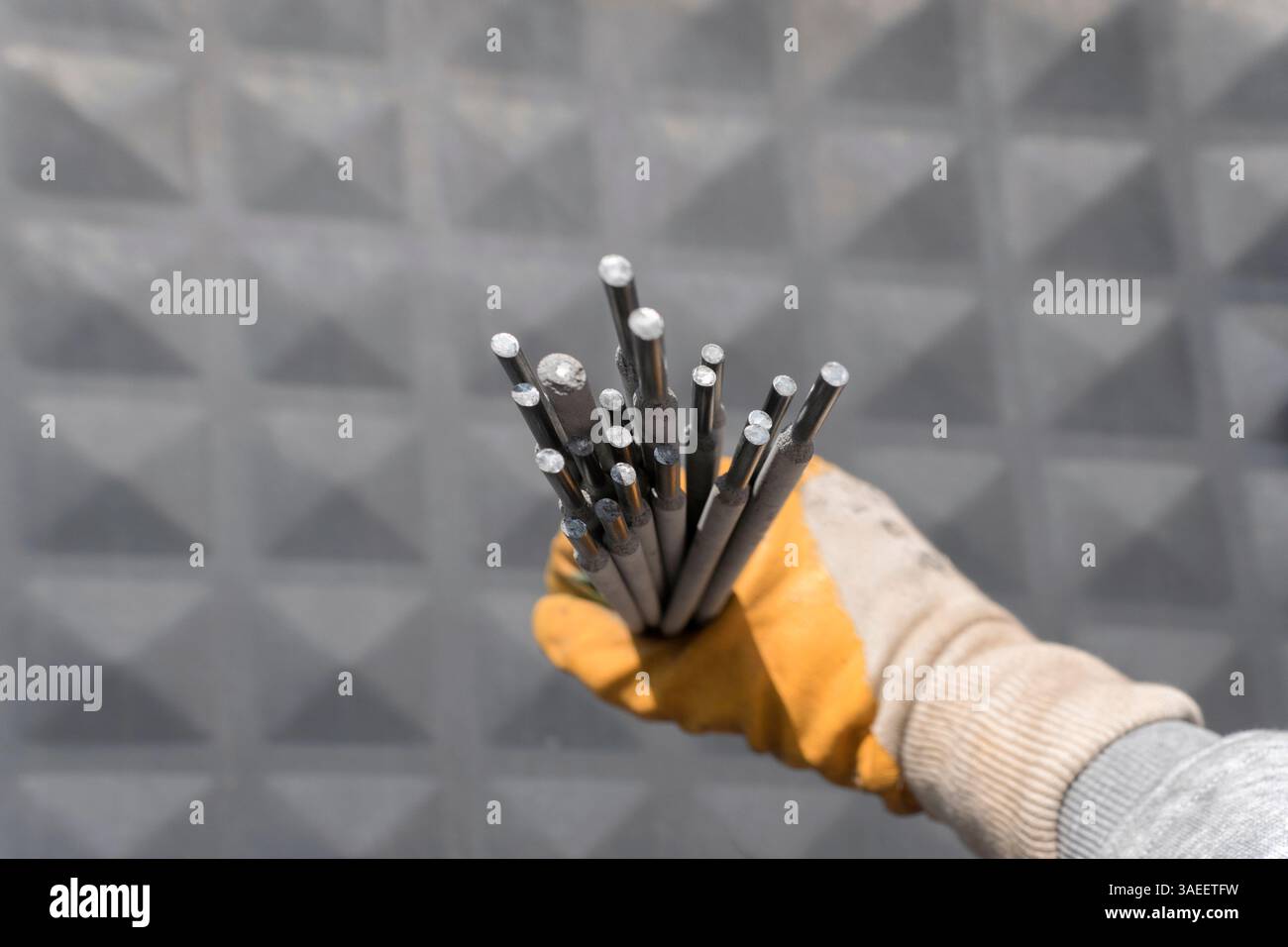 Welding electrodes in the hands of the worker. Steel welding rod ...