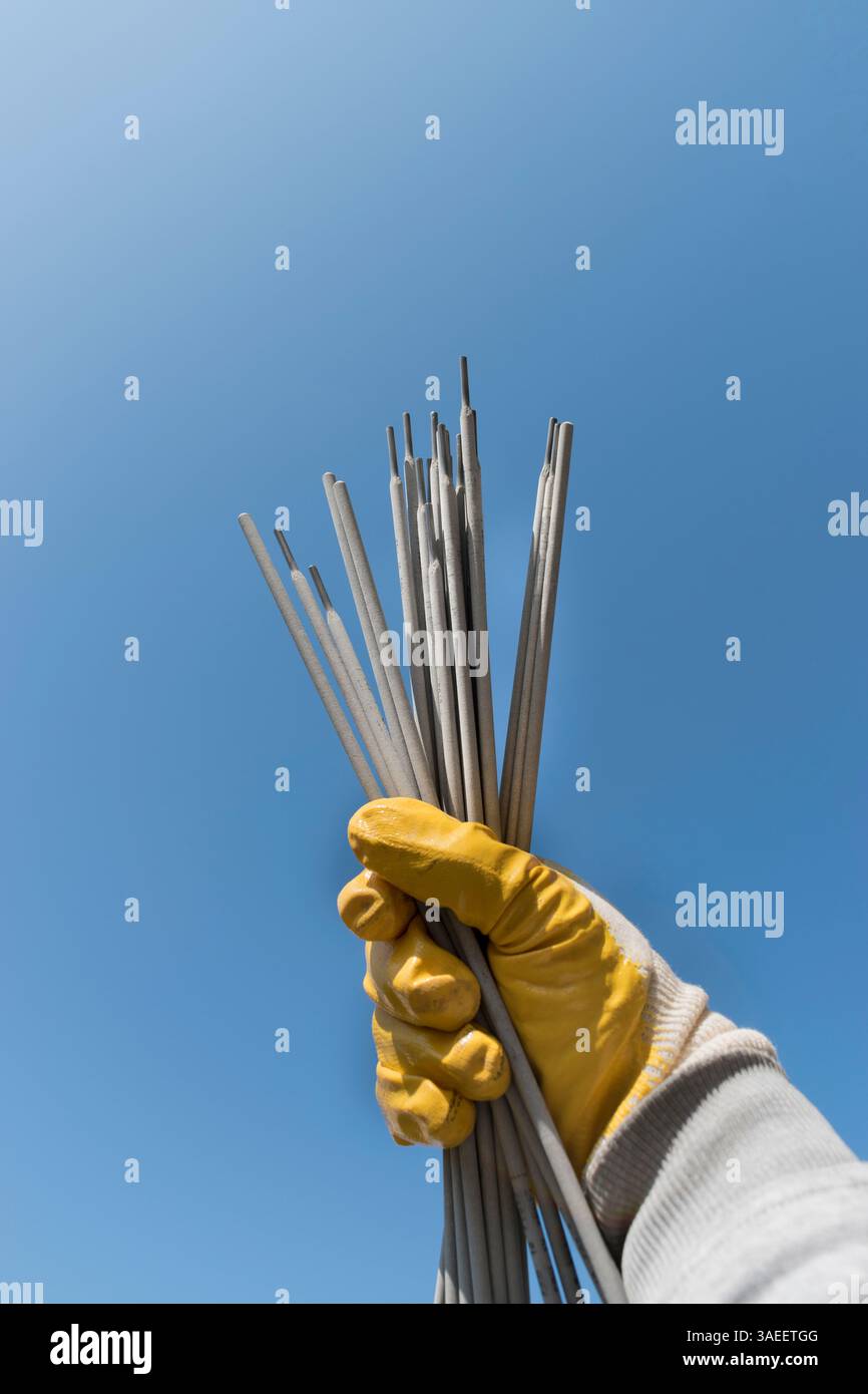 Welding electrodes in the hands of the worker. Steel welding rod ...