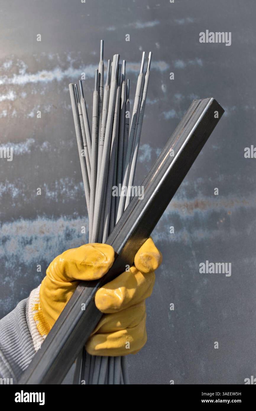 Worker ready to work with welding electrodes and metal profile. Steel ...