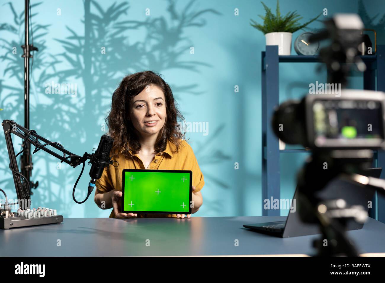 Happy influencer in studio filming mockup tablet review for tech ...