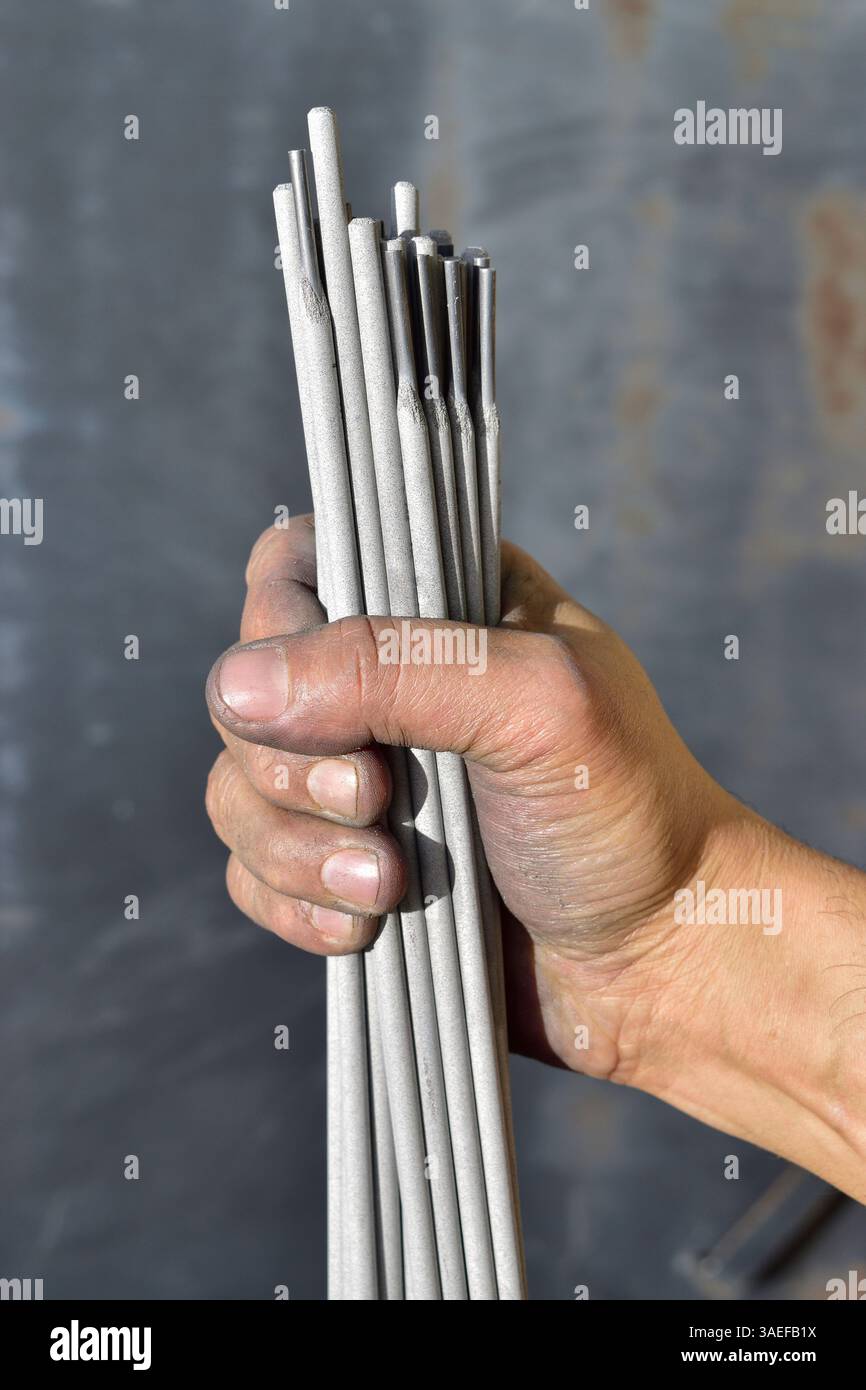 Welding electrodes in the hands of the worker. Steel welding rod ...