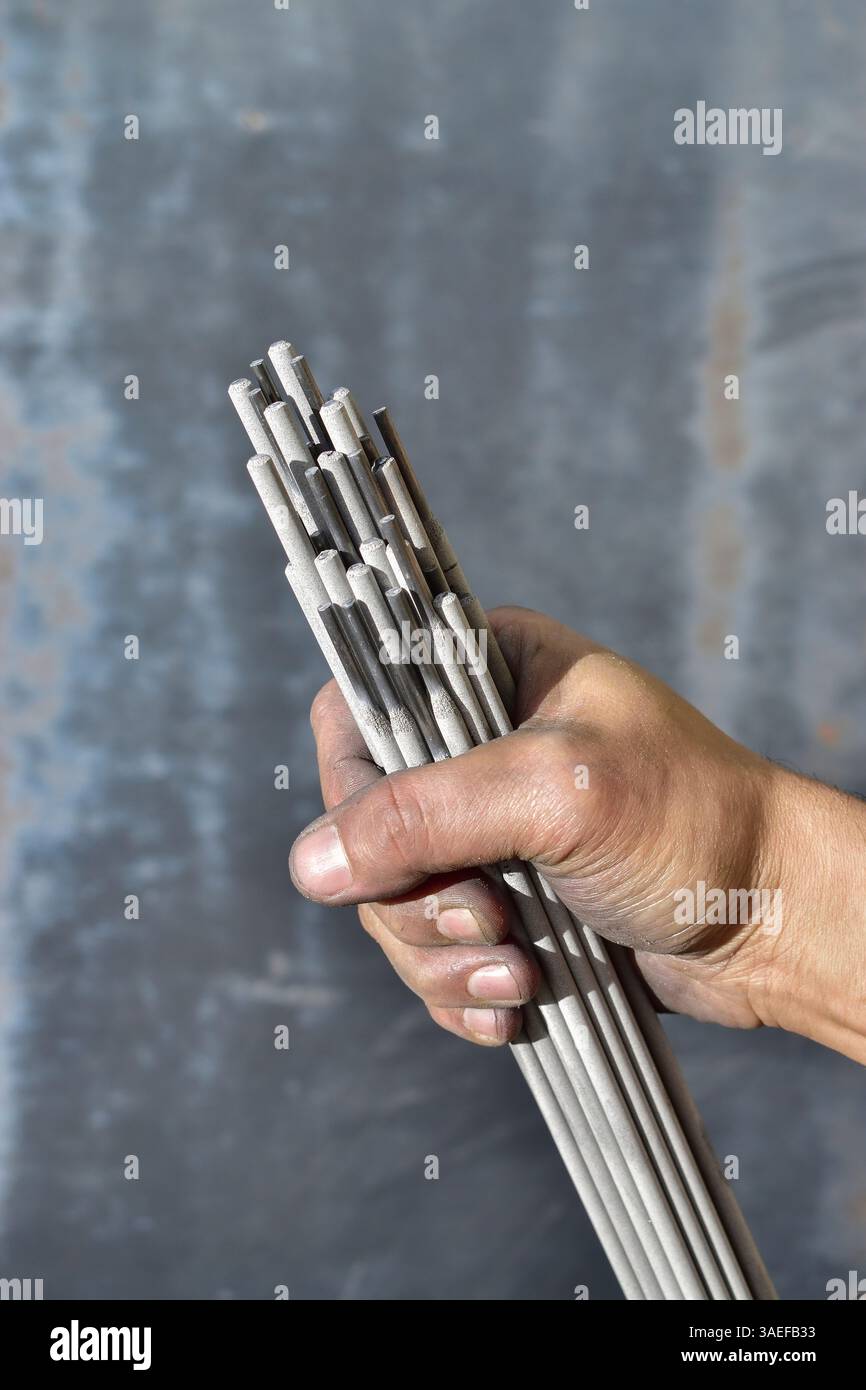 Welding electrodes in the hands of the worker. Steel welding rod ...