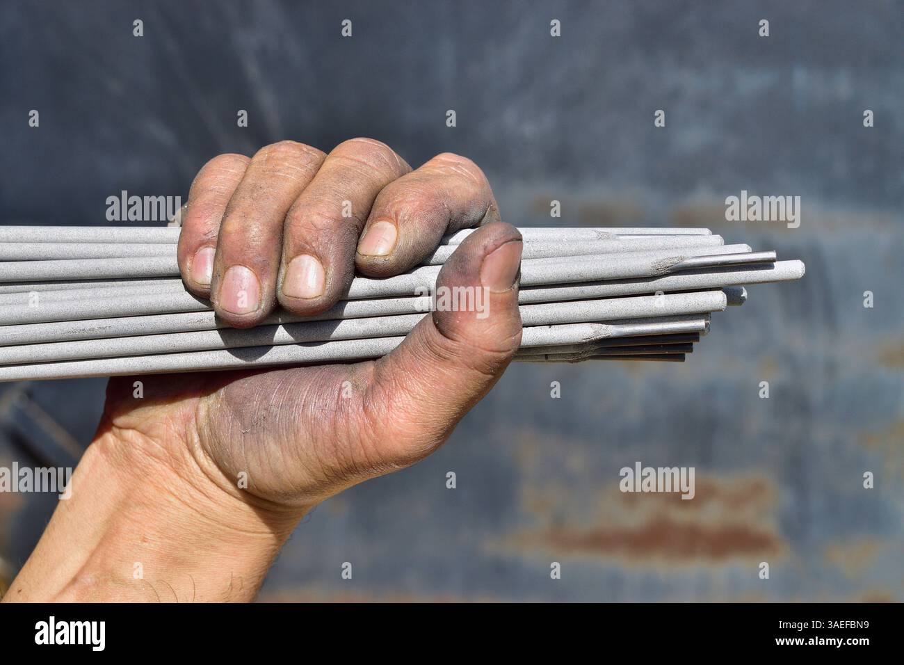Welding electrodes in the hands of the worker. Steel welding rod ...