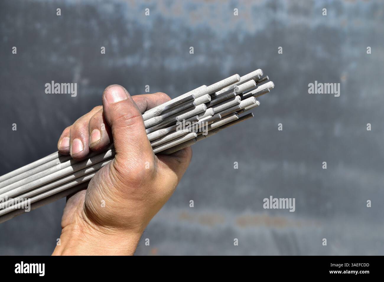 Welding electrodes in the hands of the worker. Steel welding rod ...