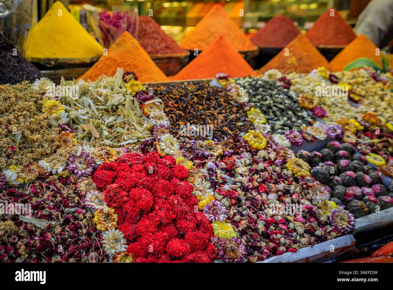 Colorful dried flowers herbs and aromatic spices arranged on a bustling ...