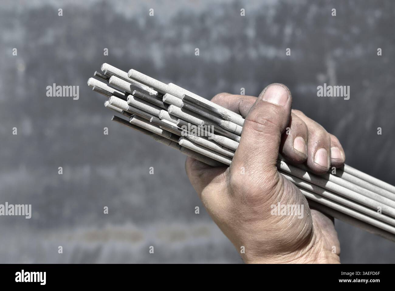 Welding electrodes in the hands of the worker. Steel welding rod ...