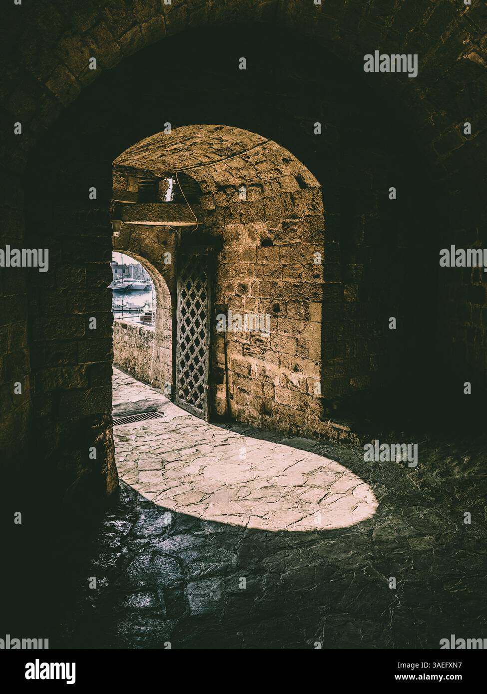 Historic arched stone corridor with natural light casting onto the ...