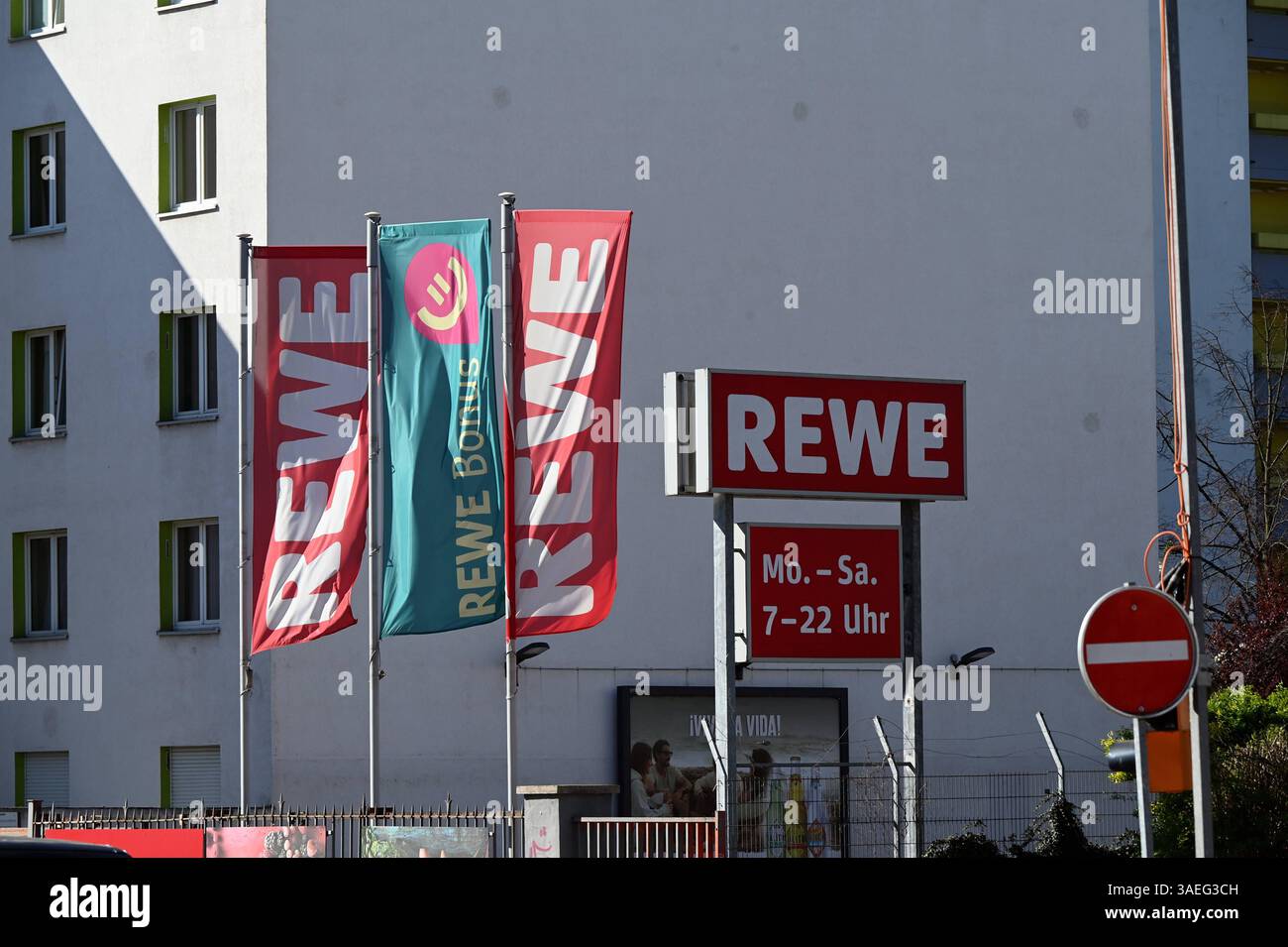 Fahnen des Einzelhändler REWE mit Werbung für REWE Bonos wehen im Wind ...