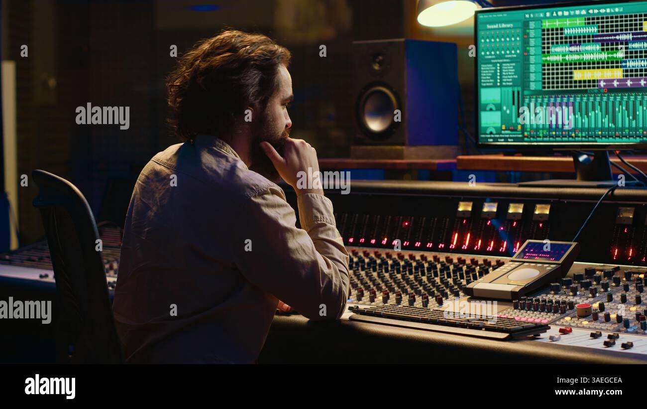 Music producer editing sounds with mixing console and switchers to ...