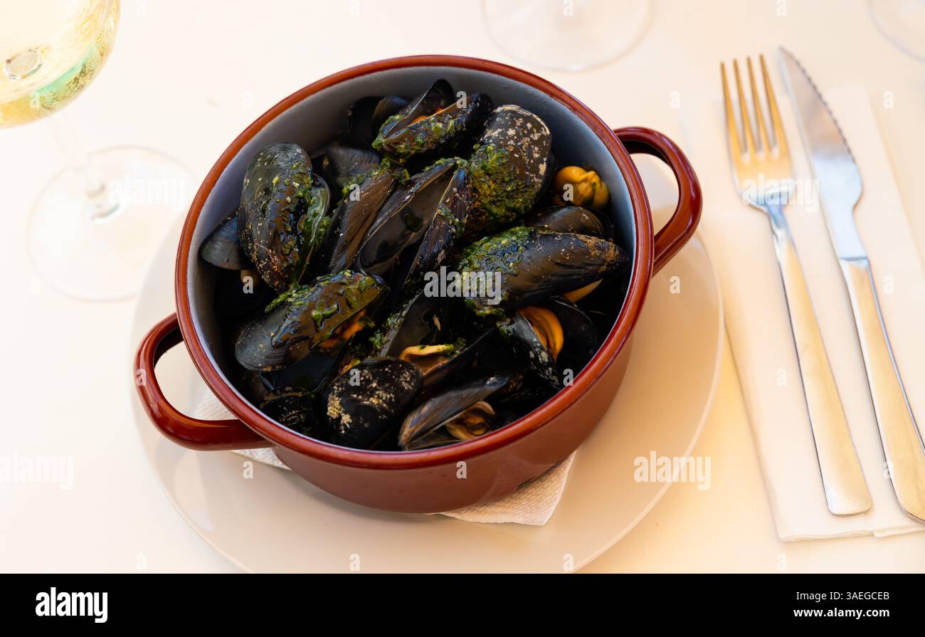 Steam cooked mussels with garlic sauce in earthenware pan Stock Photo ...