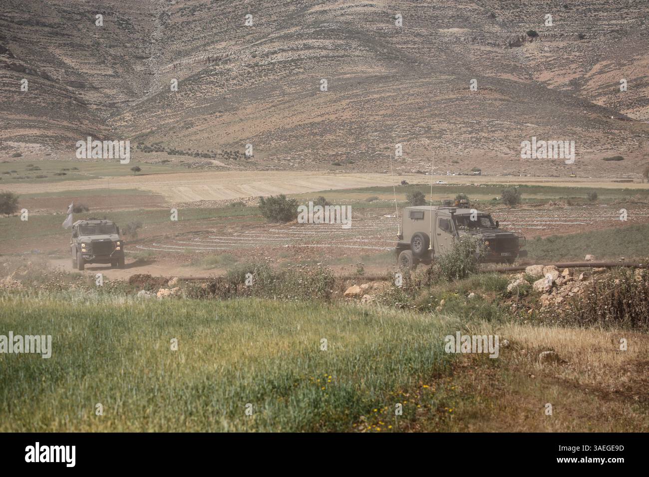 Israeli military vehicles guard the area during the demolition of ...