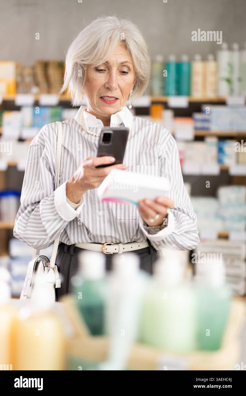 Elderly woman scanning qr code of pills Stock Photo - Alamy