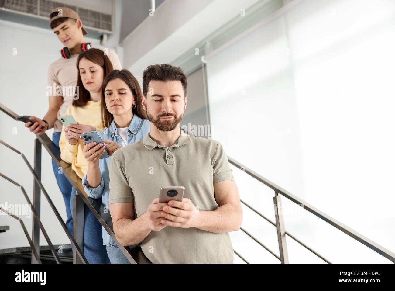 Internet addiction. Group of people with smartphones on stairs indoors ...