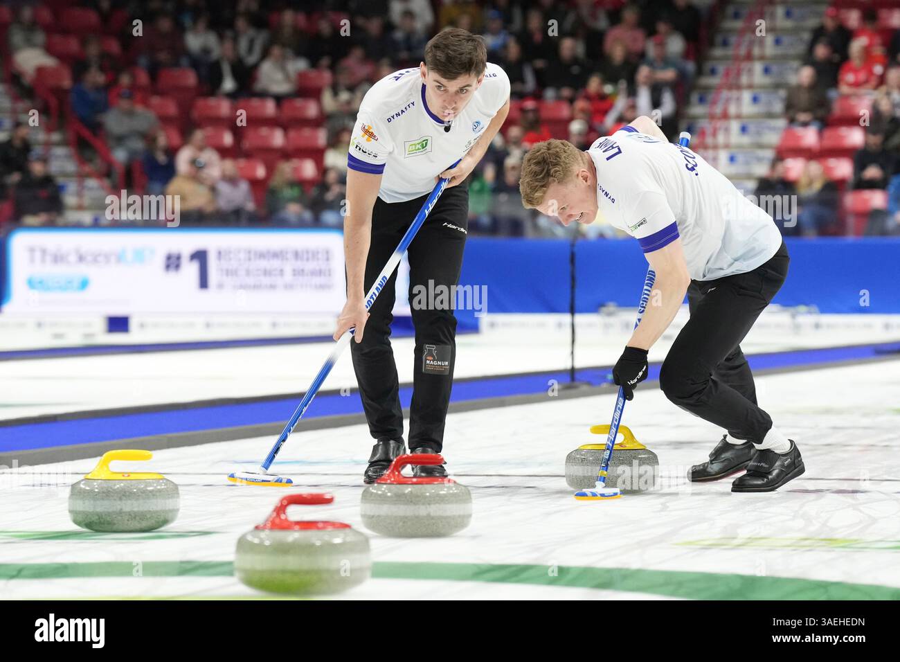 Scotland's Grant Hardie, left, and Bobby Lammie, right, sweep a stone ...