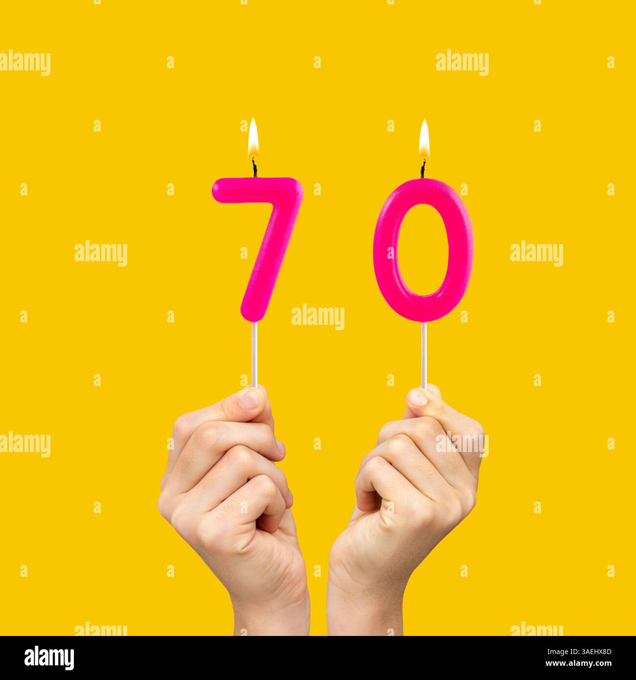 Hands holding birthday candles with number 70 - Yellow background Stock ...