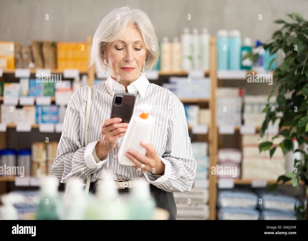 Elderly woman scanning qr code of cream Stock Photo - Alamy