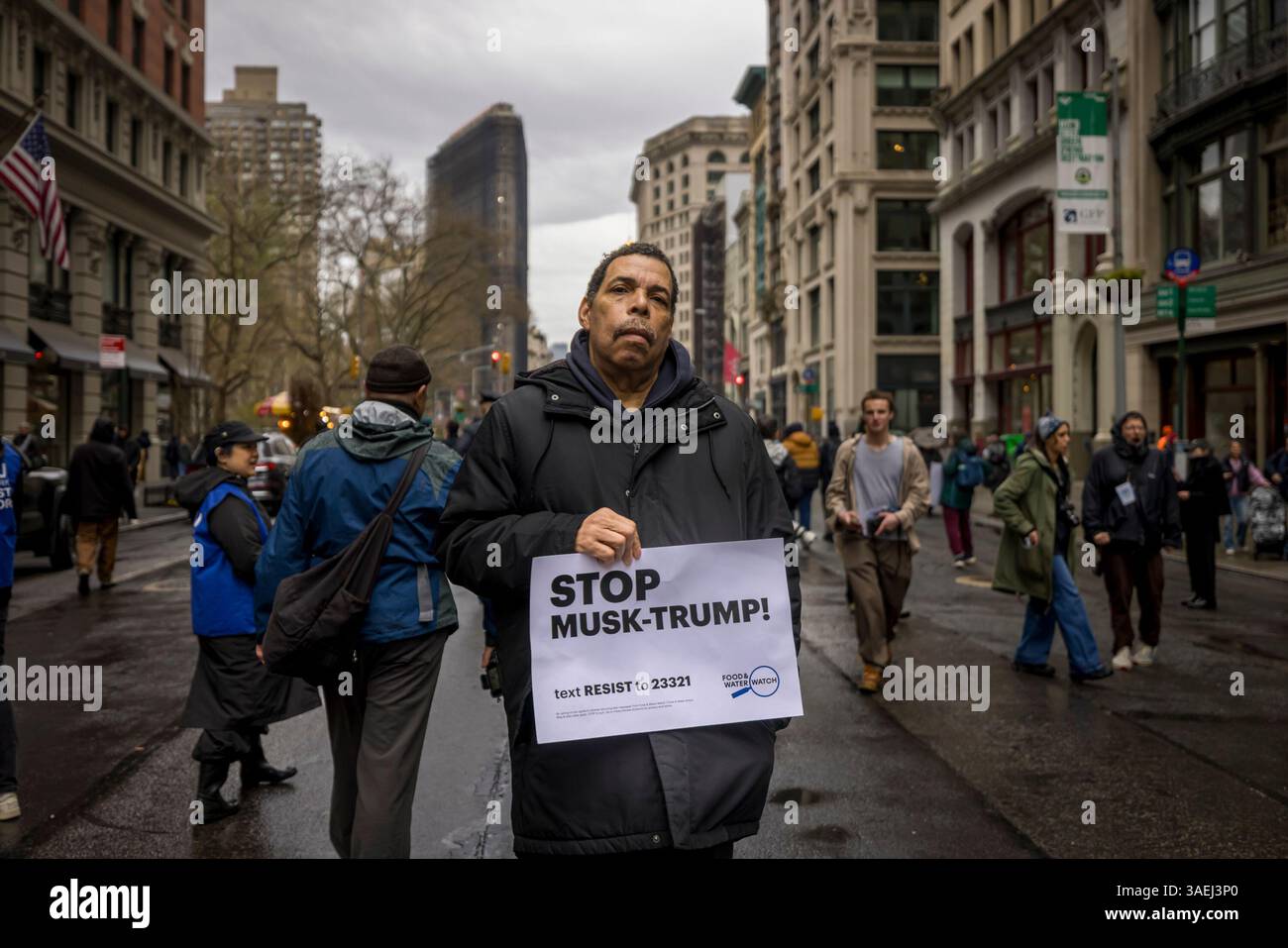 A person holds a sign that reads, "Stop Musk-Trump," as tens of ...