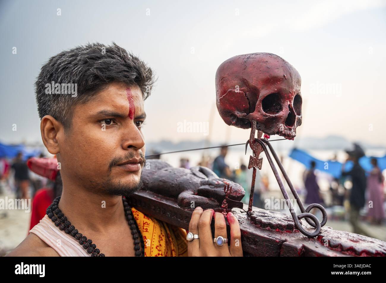 A Hindu priest arrives awith a human skull on the bank of Brahmaputra ...