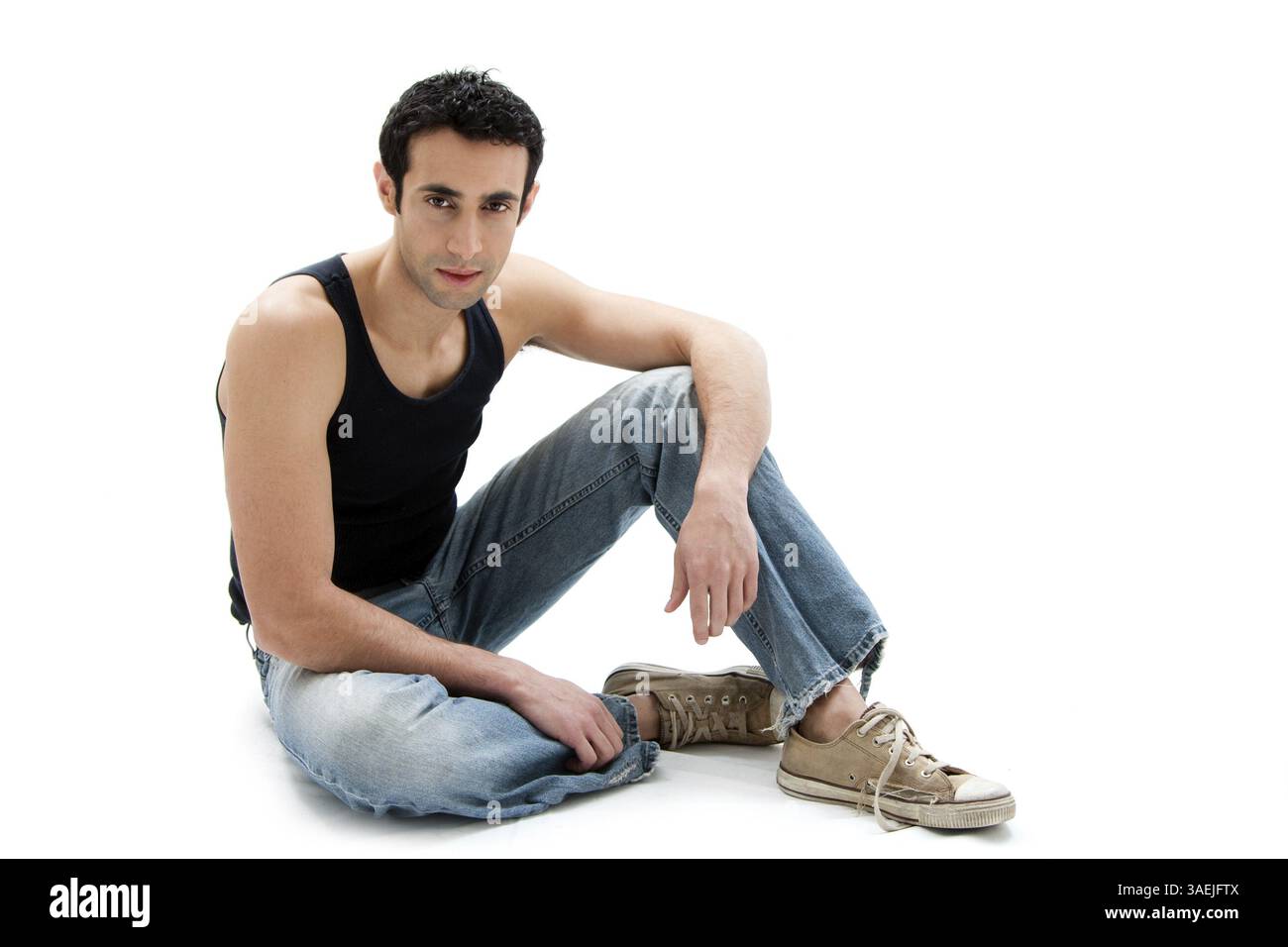 Handsome Caucasian guy wearing black tank top and jeans sitting on ...