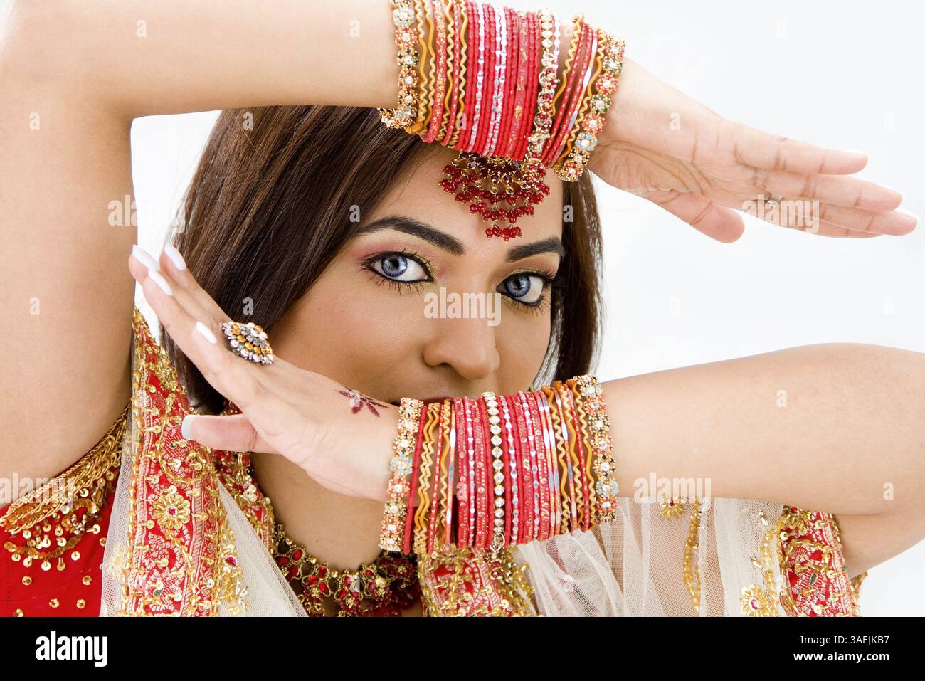 Beautiful face of a Bengali bride with her arms across her head covered ...